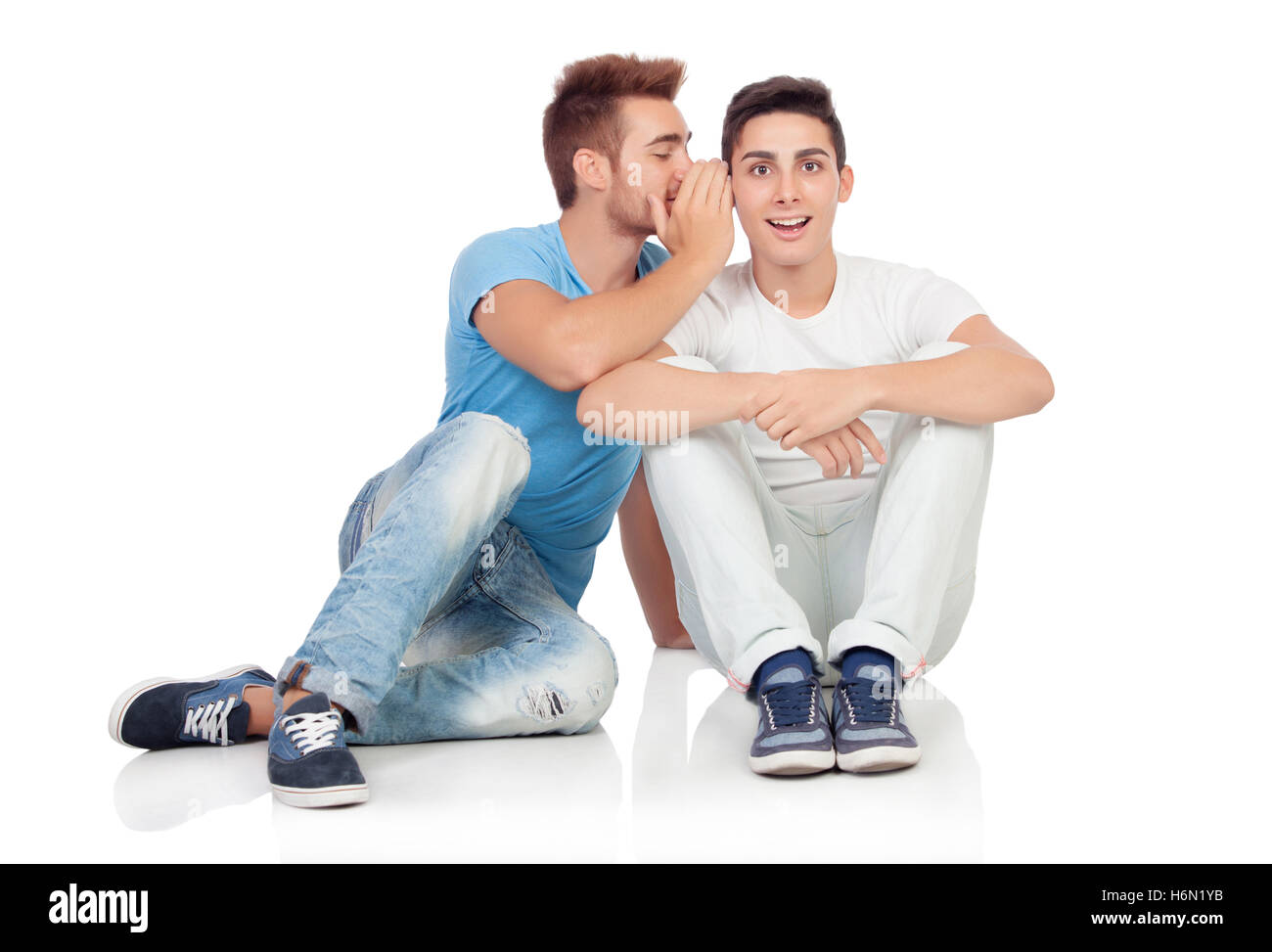 Two brothers whispering isolated on a white background Stock Photo - Alamy