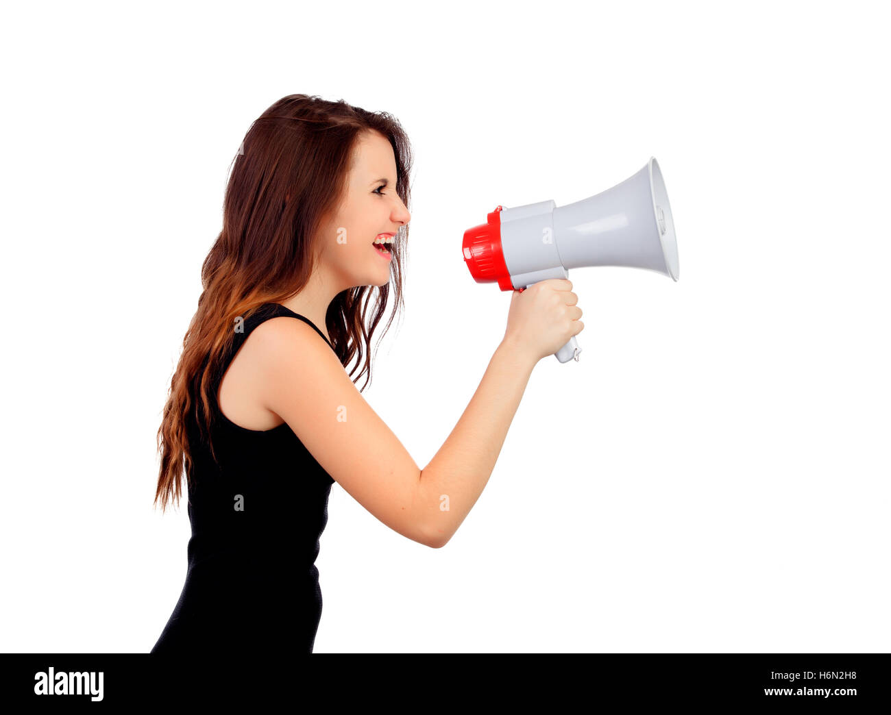 Funny girl shouting with a megaphone isolated on a white background ...