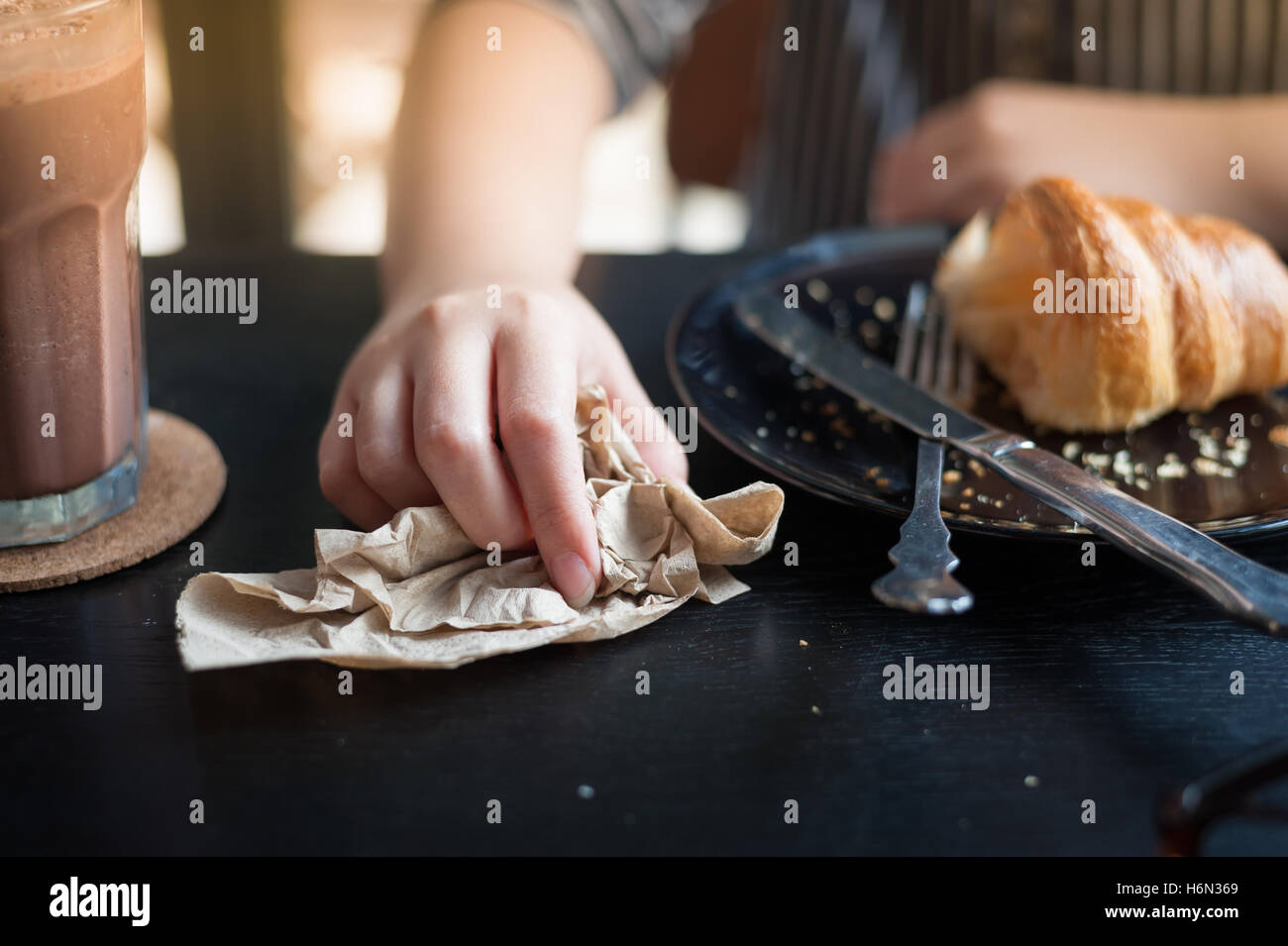 Woman right hand wipe on brown paper napkin on wood table in cafe Stock ...