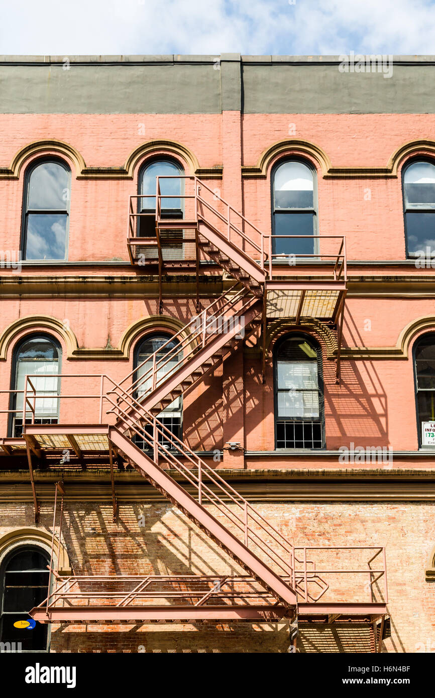 An old red rusty fire escape down a brick building Stock Photo - Alamy