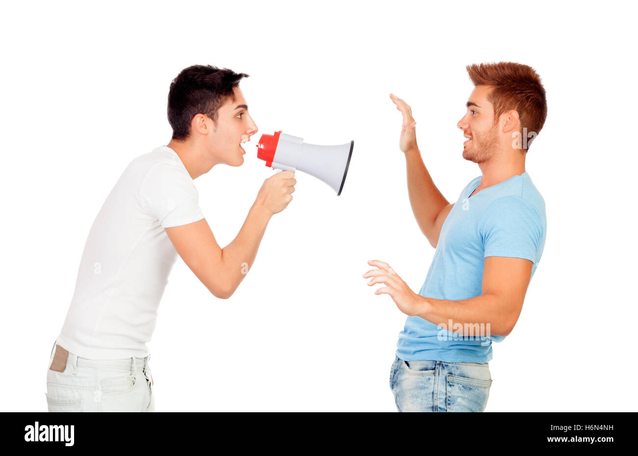 Young men screams to his friend through a megaphone isolated on a white ...