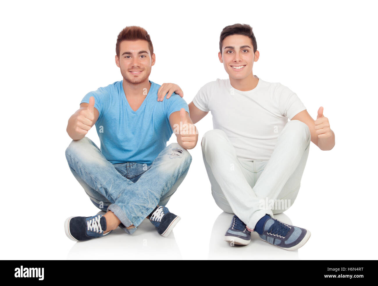 Portrait of two brothers sitting saying Ok isolated on a white ...