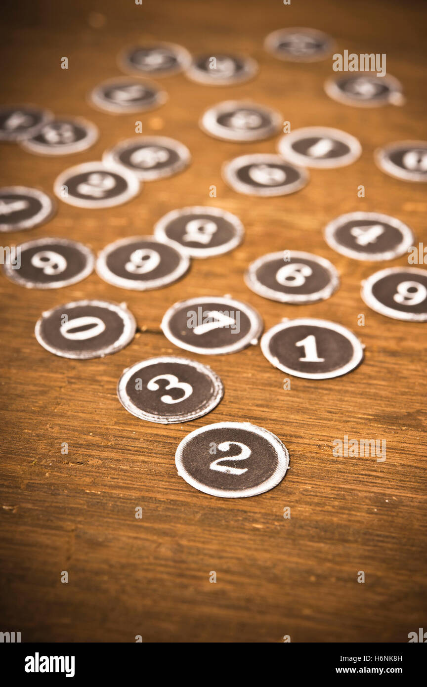 scattered round paper cut with numbers printed on it Stock Photo - Alamy