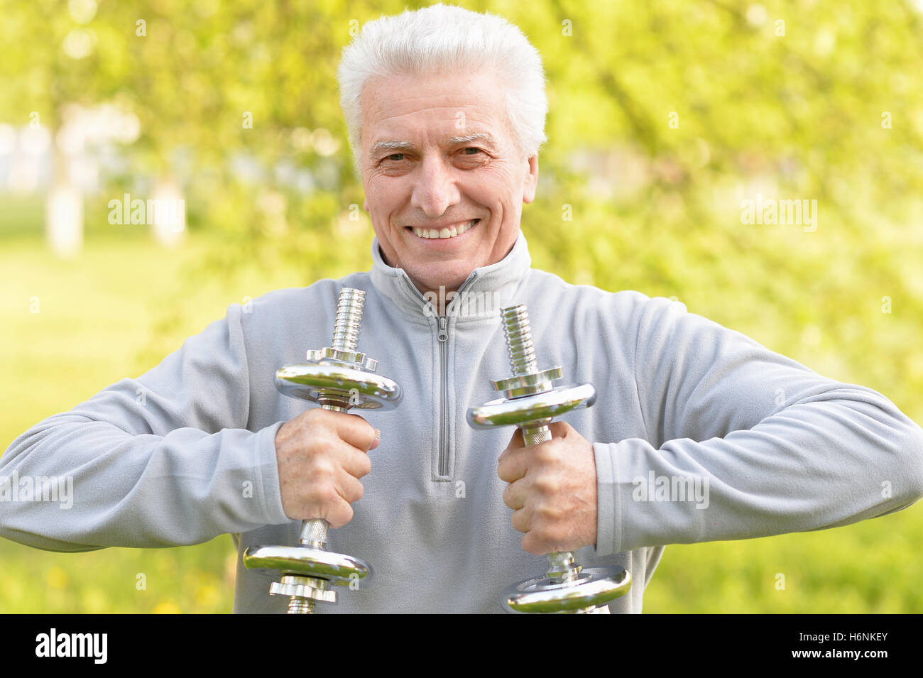 Elderly man exercising with dumbbells Stock Photo - Alamy