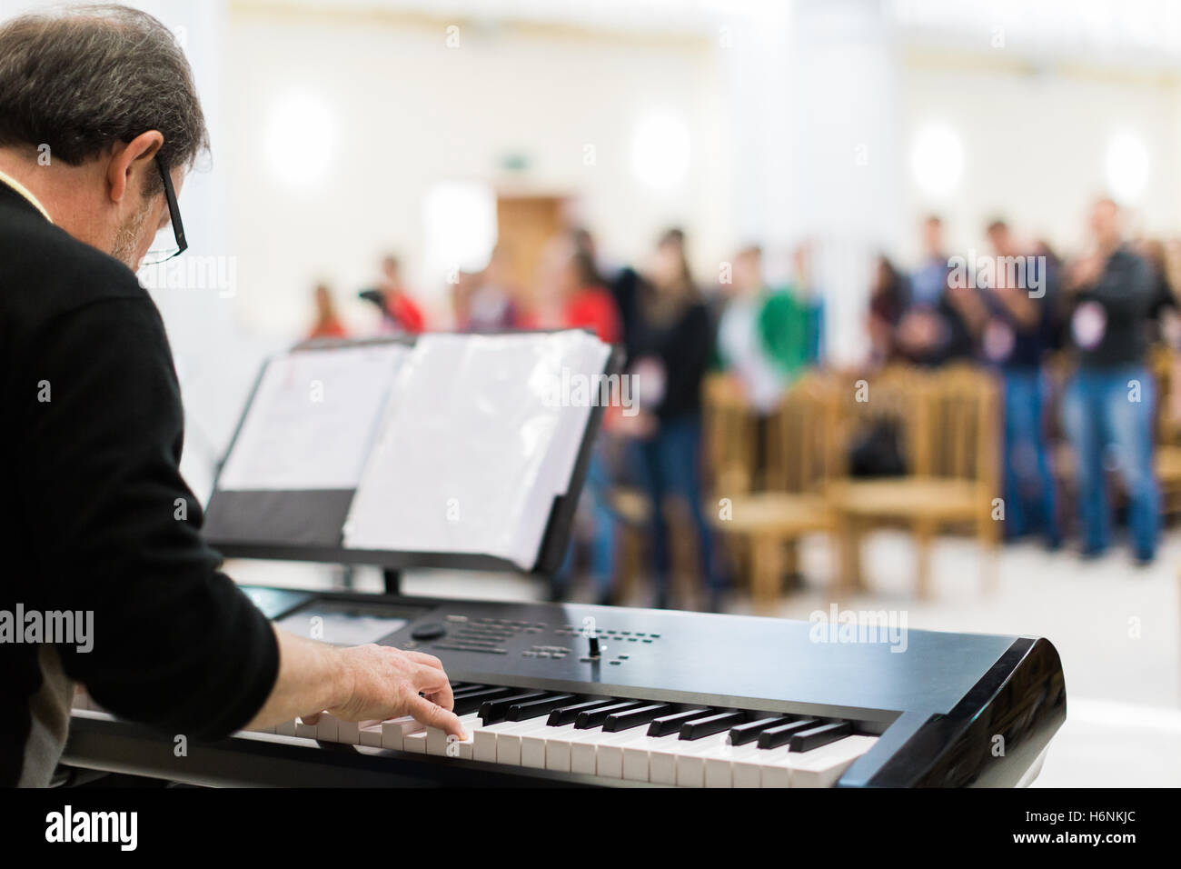 Keyboard player performing on stage live concert in front of people ...