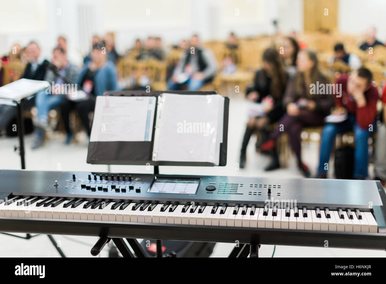 Keyboard or electric piano on stage at live concert in front of people ...