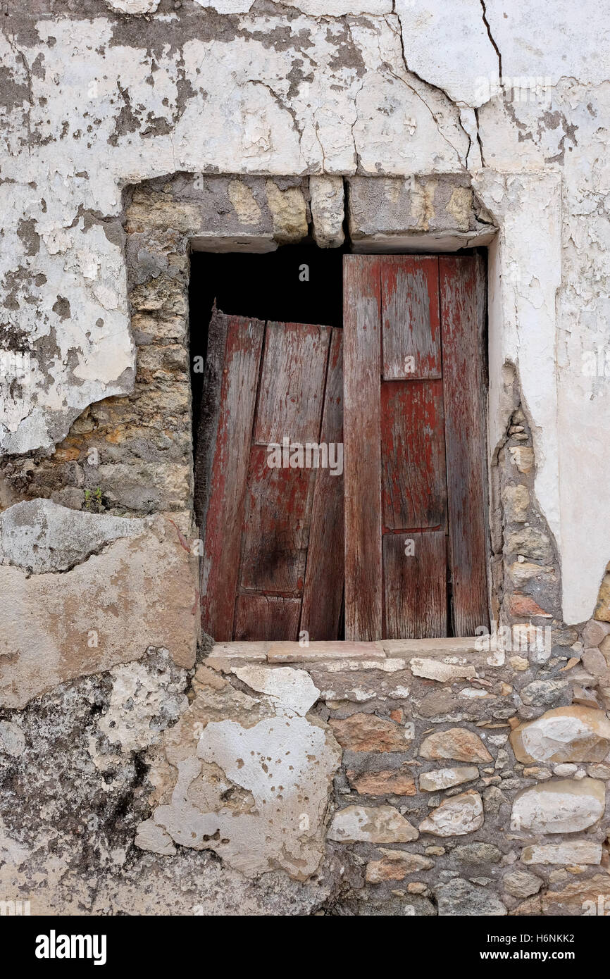 Broken wooden shutters in the window of a ruined house on the Algarve ...
