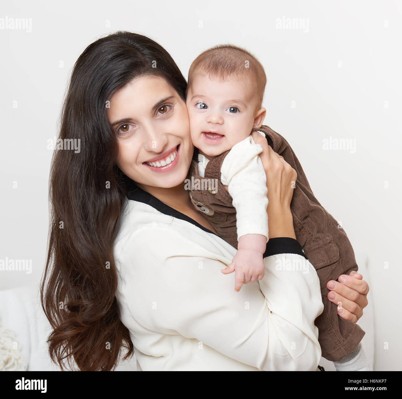 Mother raising baby and play, happy family portrait on white background ...