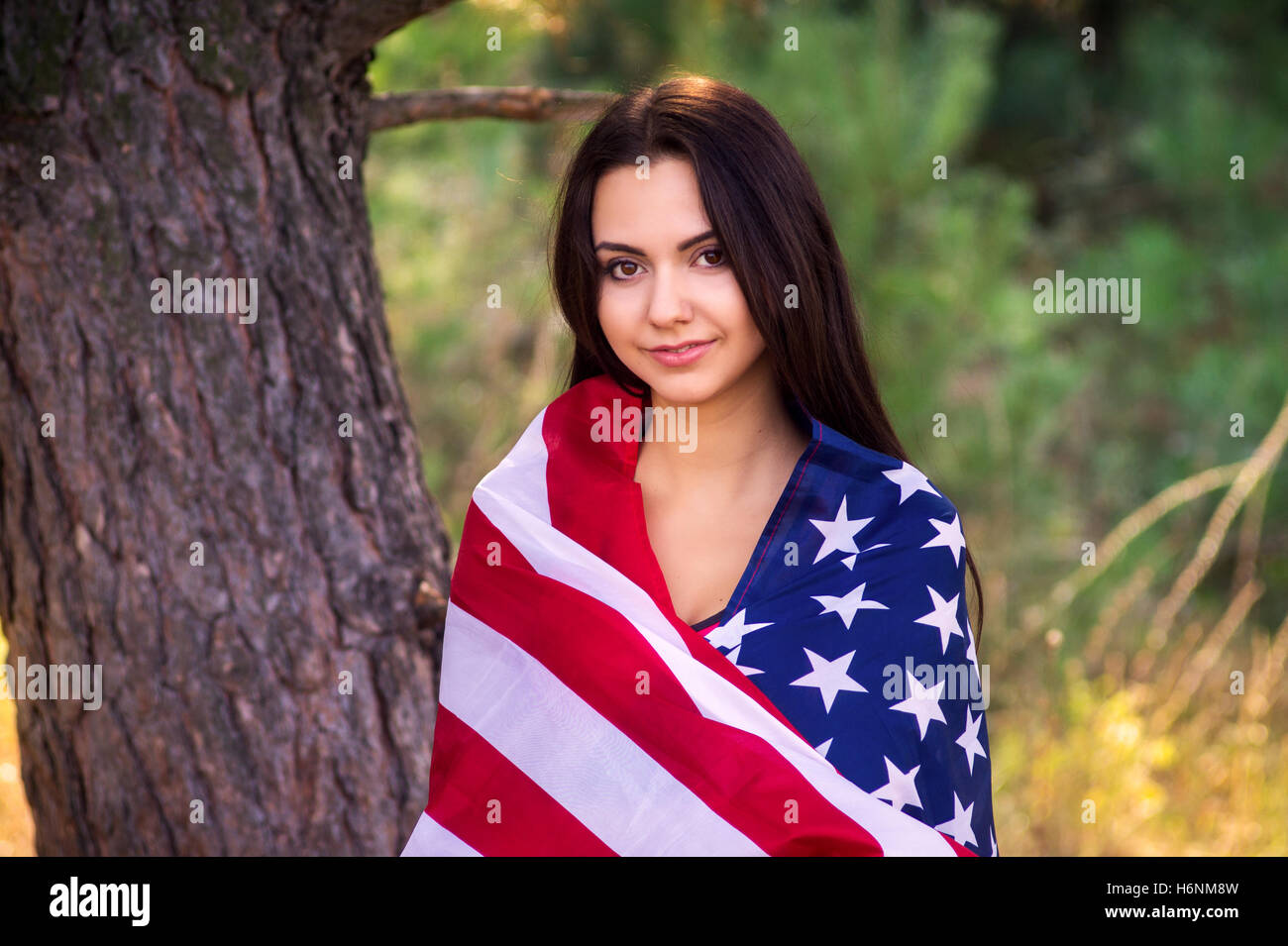 Beautiful model poses with the flag of the USA in the summer park Stock ...