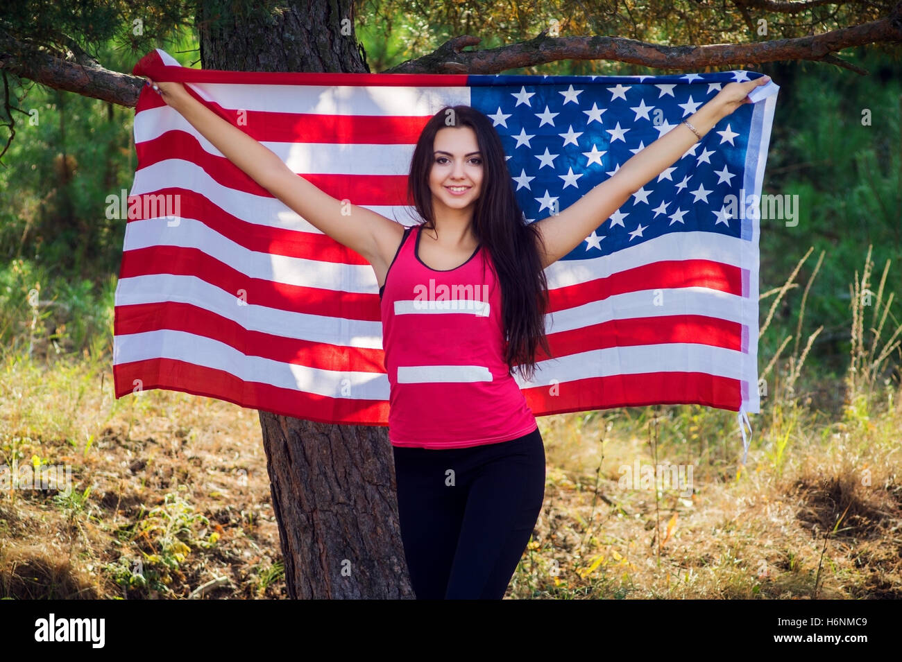 Beautiful model poses with the flag of the USA in the summer park Stock ...