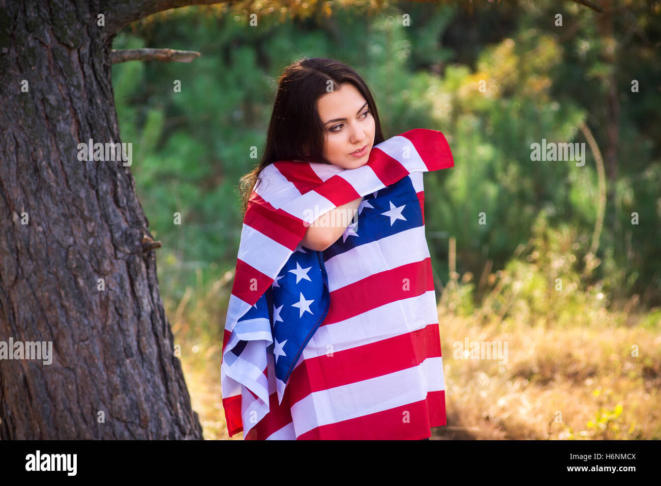 Beautiful model poses with the flag of the USA in the summer park Stock ...