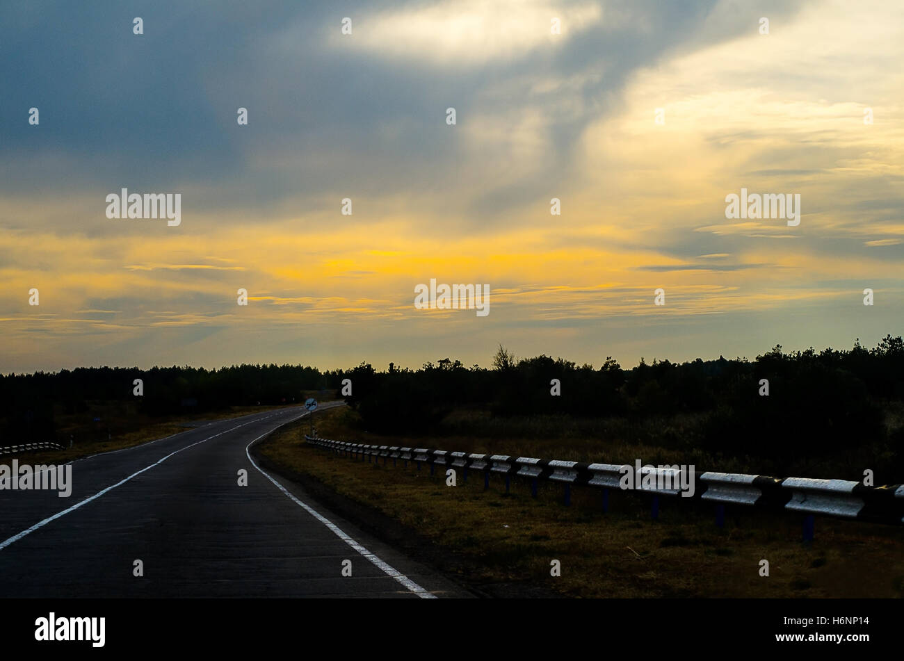 Long highway at sunset Stock Photo - Alamy
