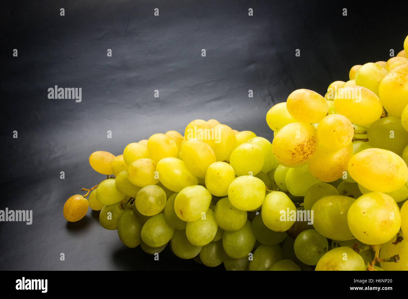 Large grapes cluster amber color on black background Stock Photo - Alamy