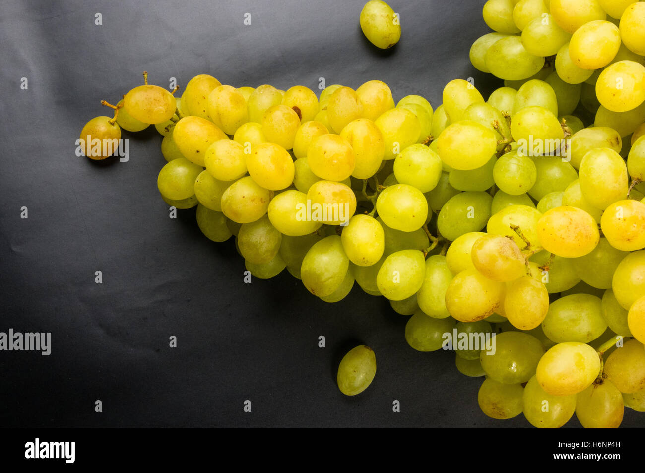 Large grapes cluster amber color on black background Stock Photo - Alamy