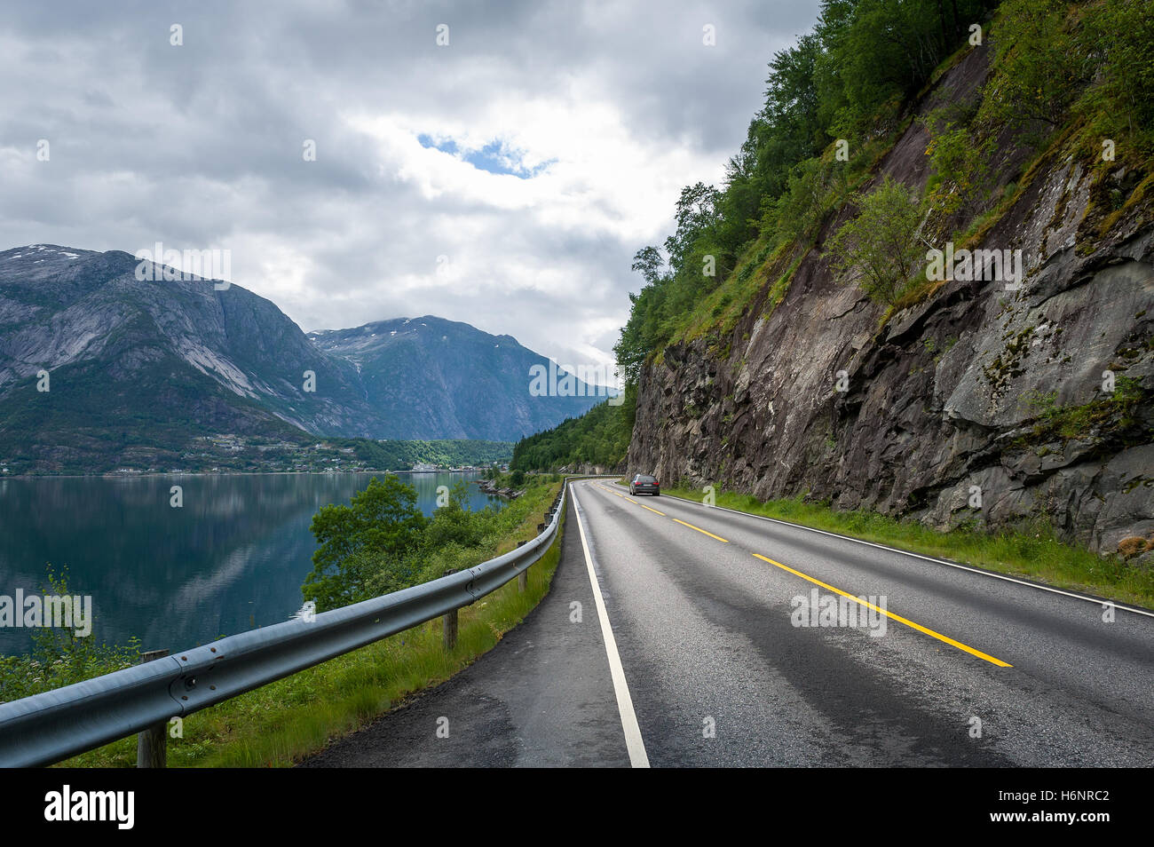 Scenic norwegian road between fjord water and steep mountain Stock ...