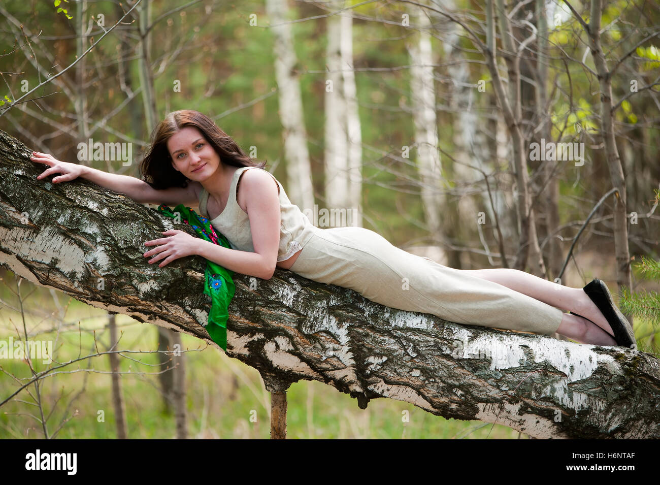 Beautiful woman on birch Stock Photo - Alamy