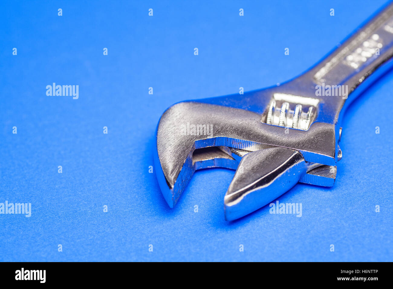 Forged steel adjustable wrench on a blue background Stock Photo - Alamy