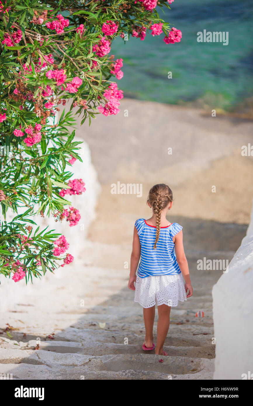Adorable girl having fun outdoors. Kid at street of typical greek ...