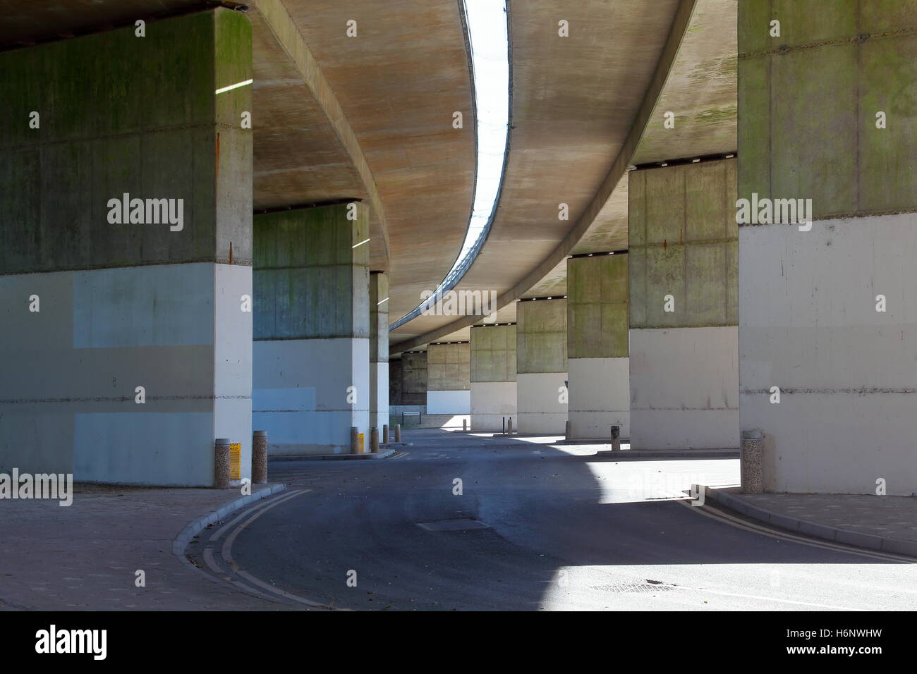 Looking along under the length of a curving dual carriageway bridge ...