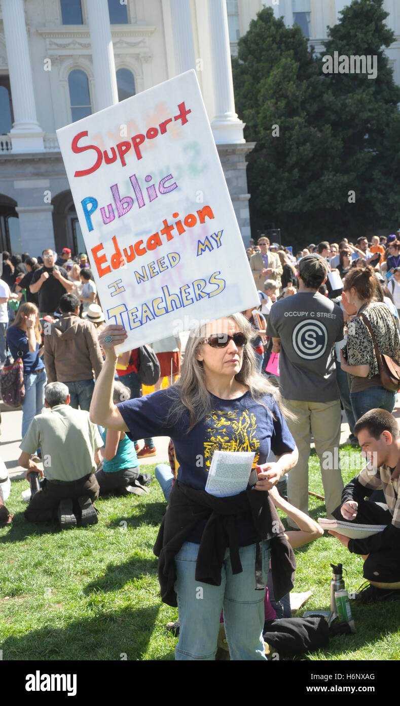 An activist holding a sign reading "Support public education I need my ...