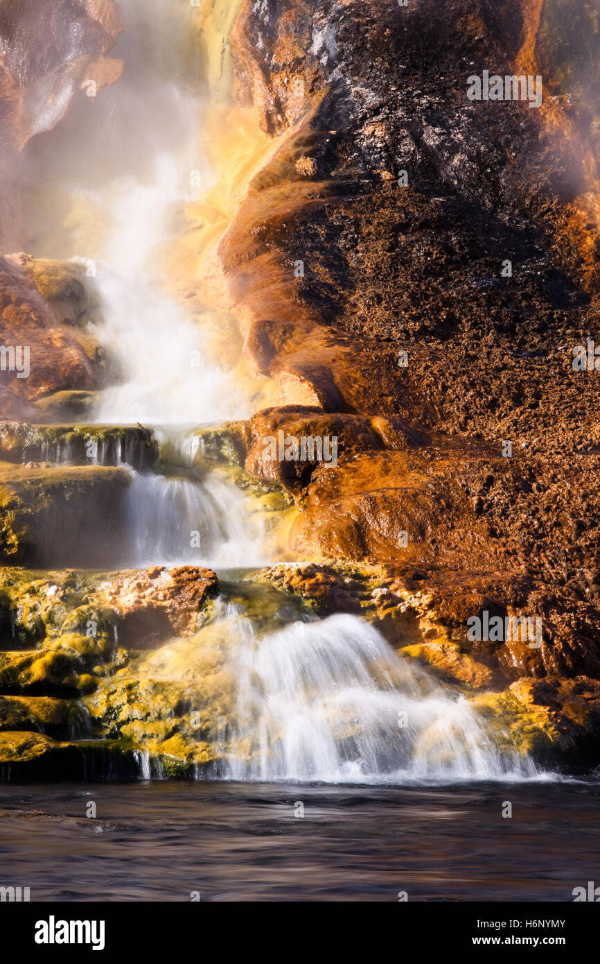 A small waterfall from a hotspring in Yellowstone National Park flows ...