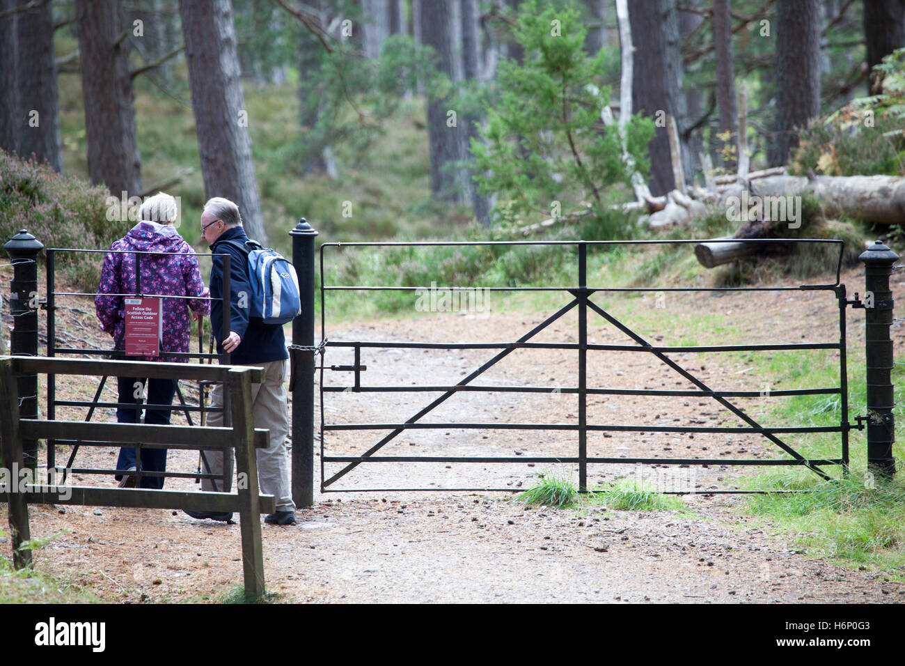 Walkers walking through closed gate along the path the contours Loch an ...