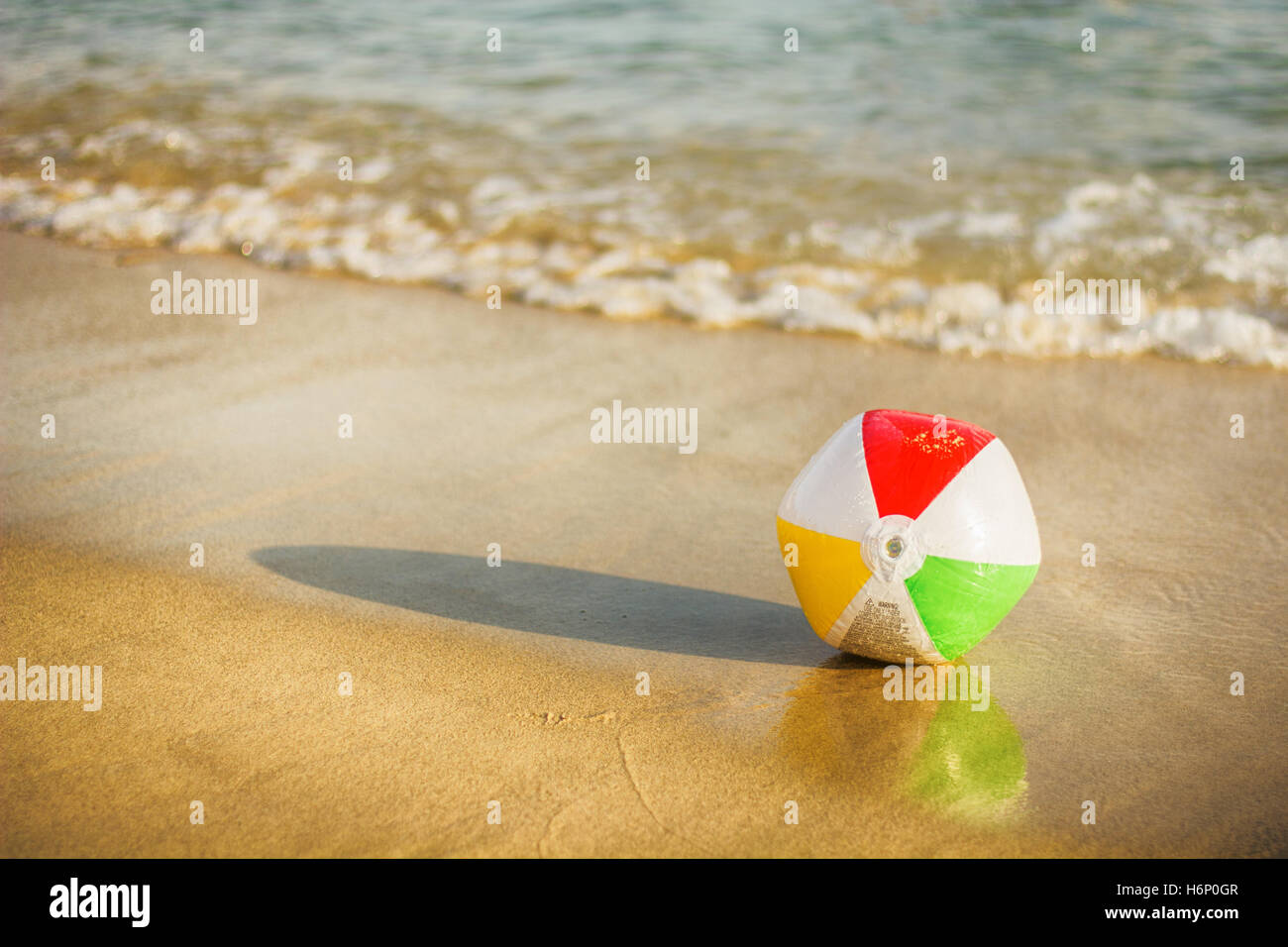 Colorful summer ball on sand beach Stock Photo - Alamy