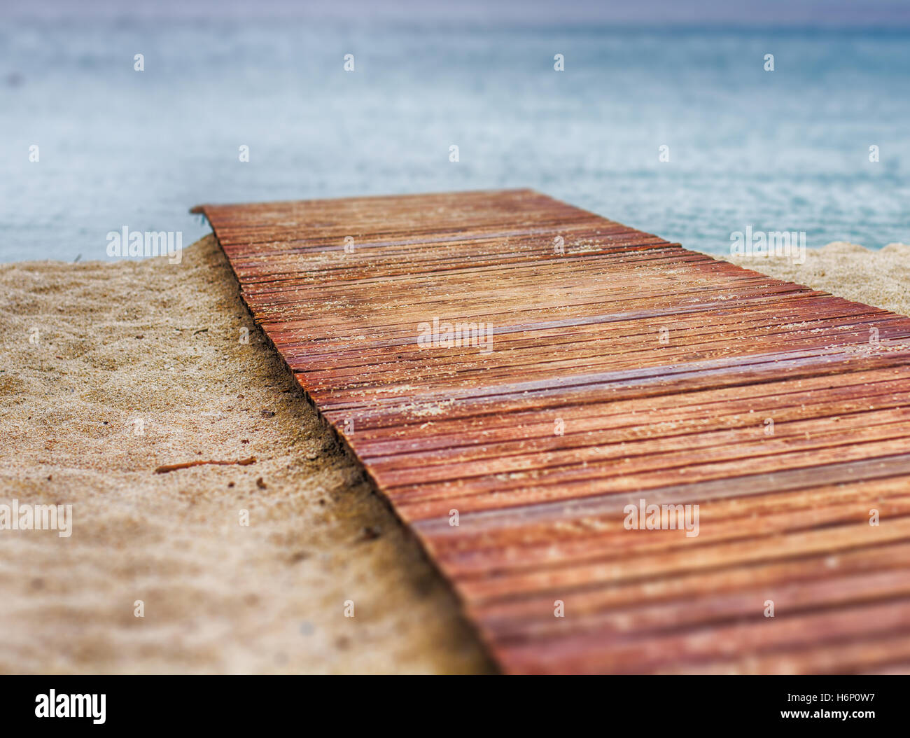 Wooden path on sand beach, sea in the background Stock Photo - Alamy