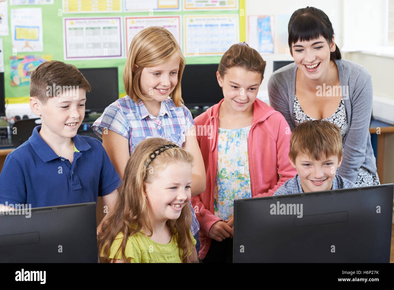 Elementary School Pupils With Teacher In Computer Class Stock Photo - Alamy