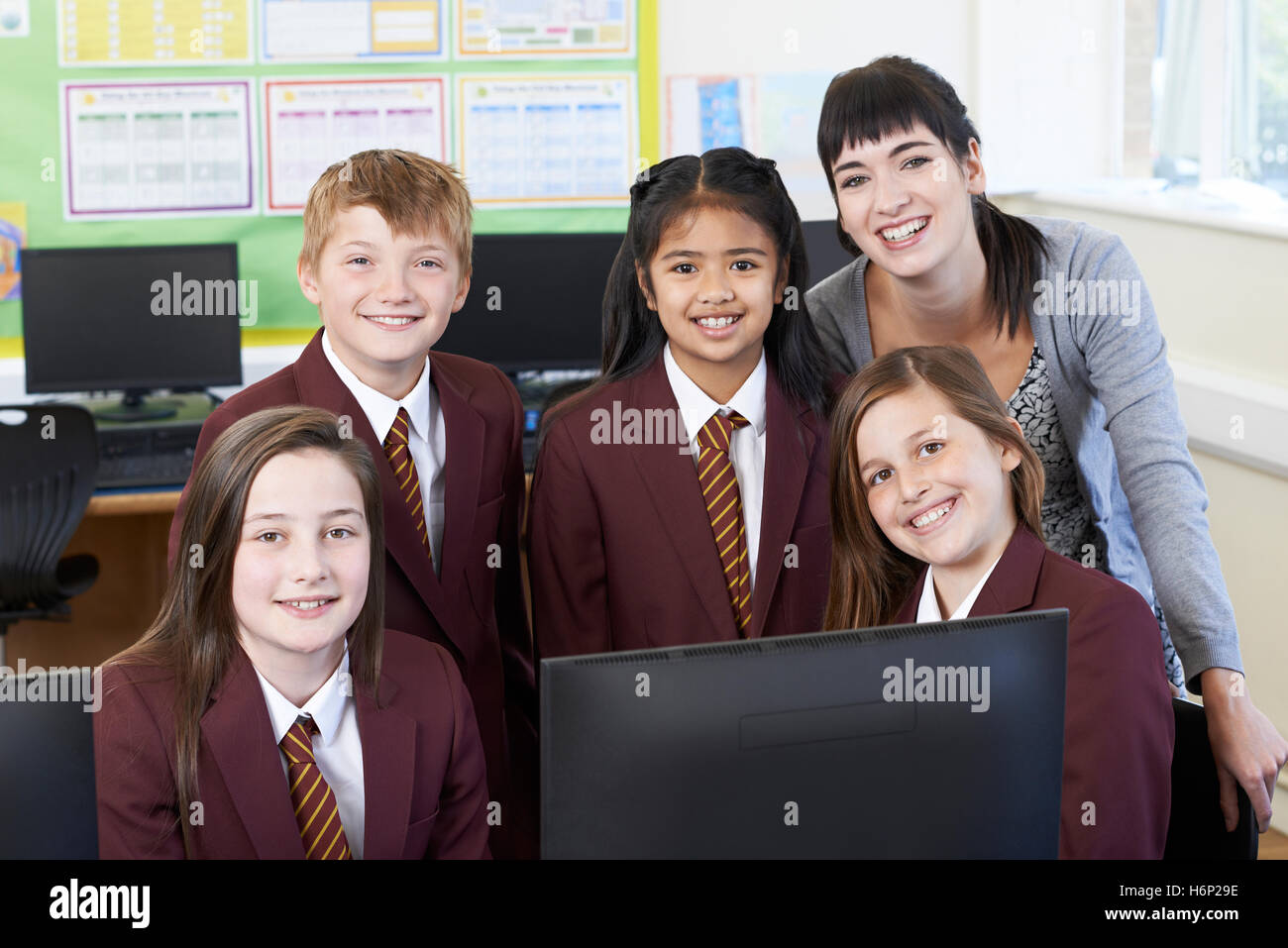 Portrait Of Elementary School Pupils With Teacher In Computer Class ...