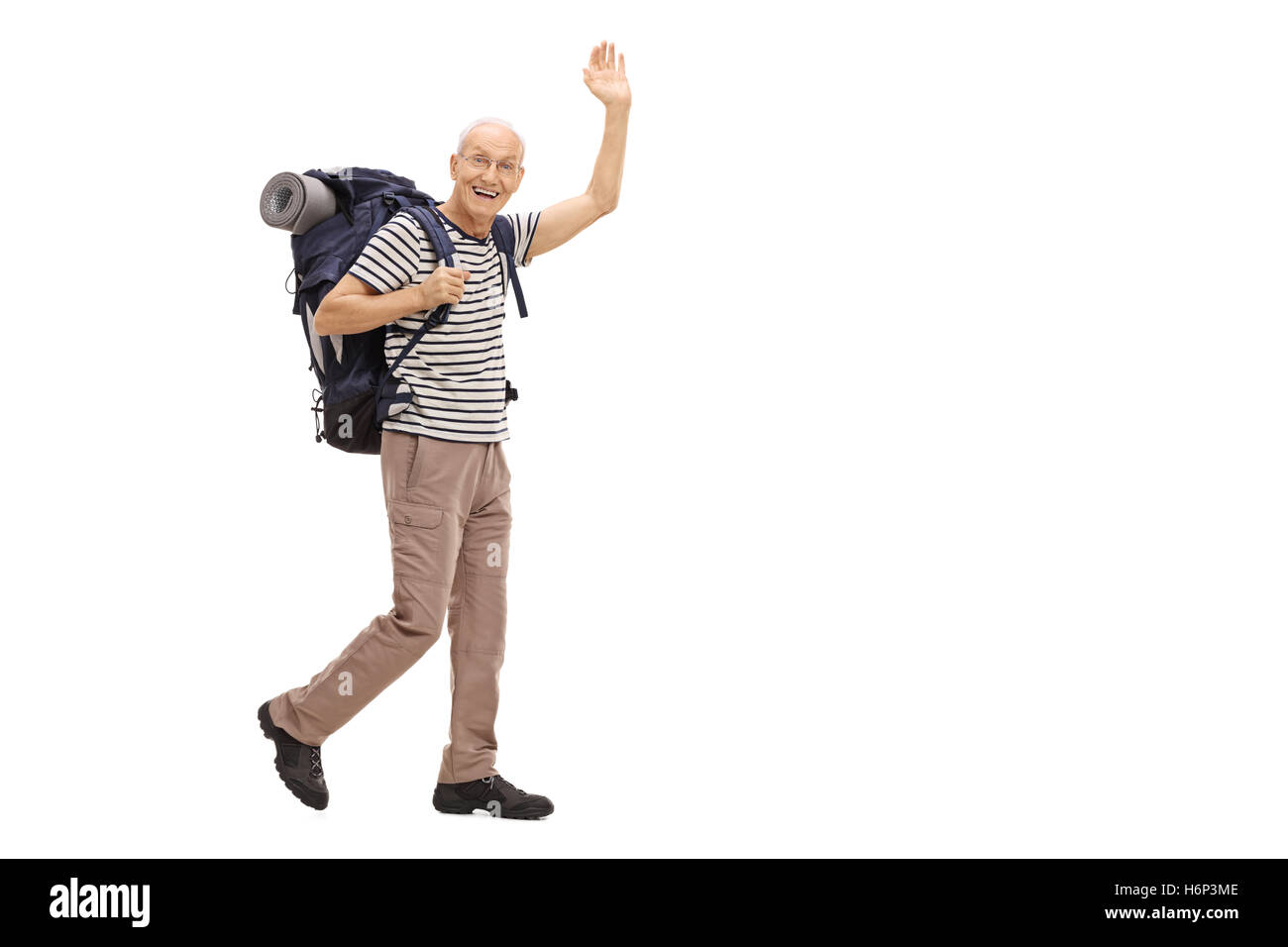 Full length portrait of an elderly hiker walking and waving at the ...