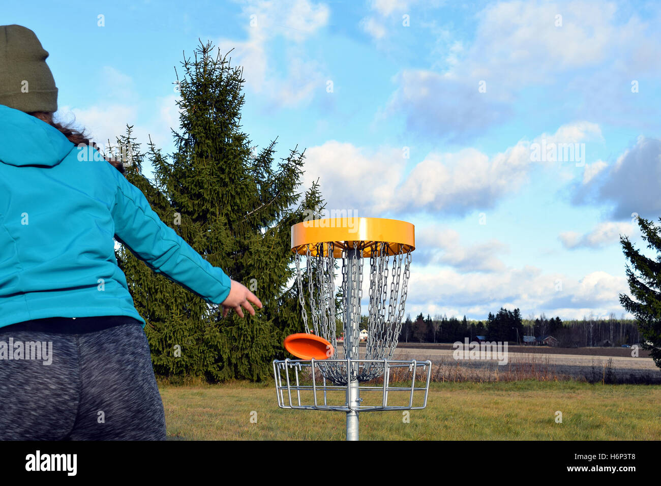 Young woman throwing disc to target on disc golf course Stock Photo - Alamy