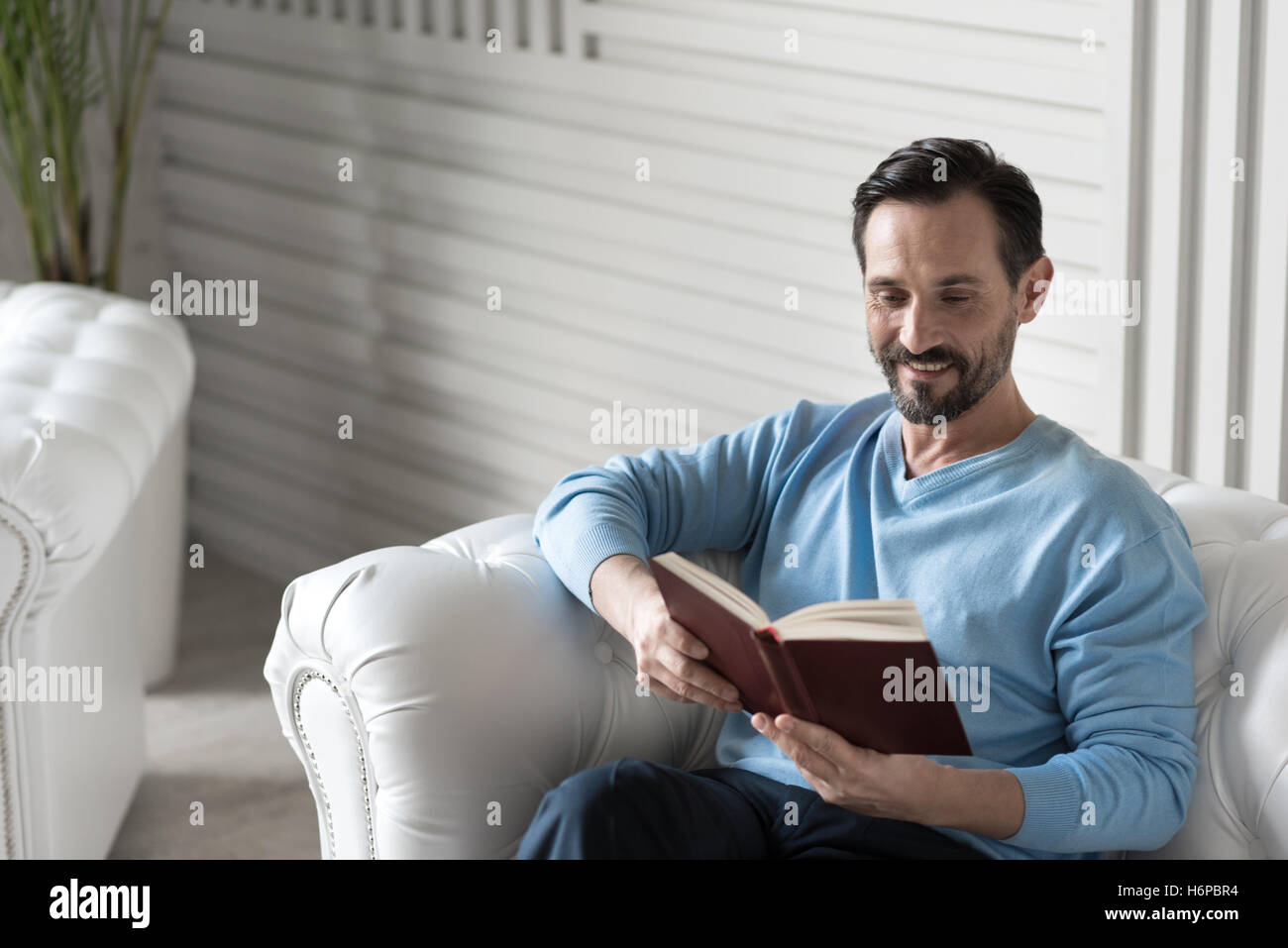 Happy intelligent man reading a book Stock Photo - Alamy