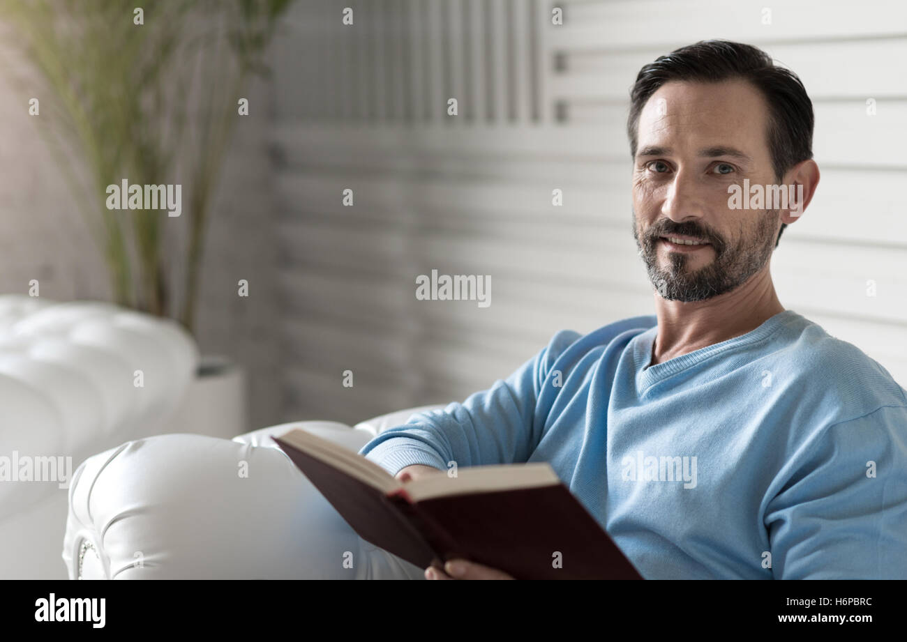 Nice delighted man reading a story Stock Photo - Alamy