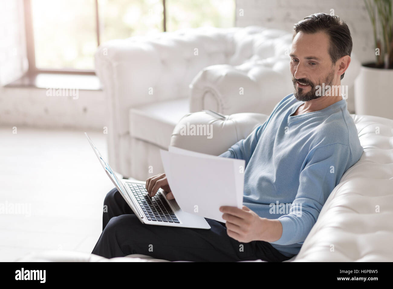 Cheerful responsible man looking at the documents Stock Photo - Alamy