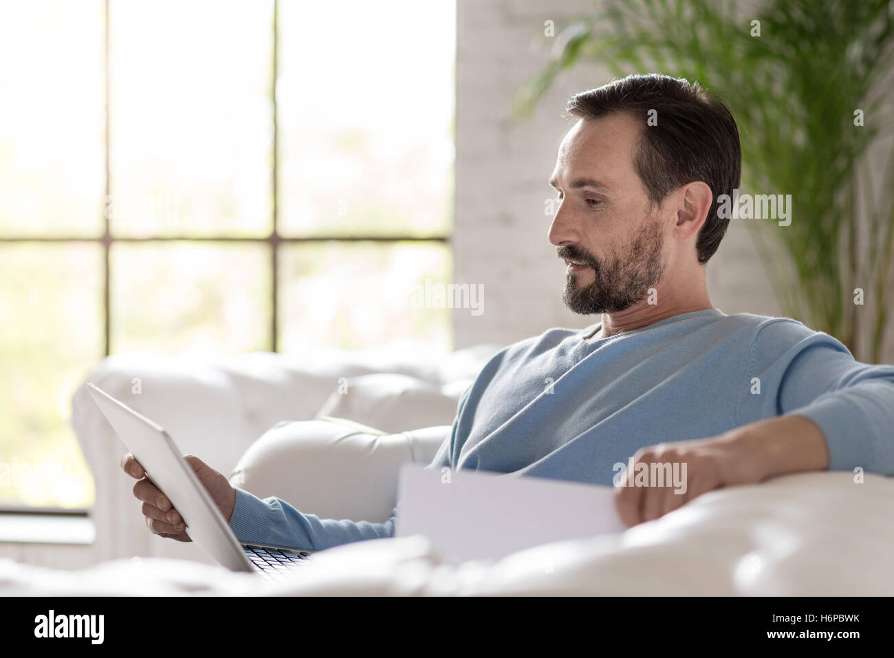 Serious adult man looking at his laptop Stock Photo - Alamy