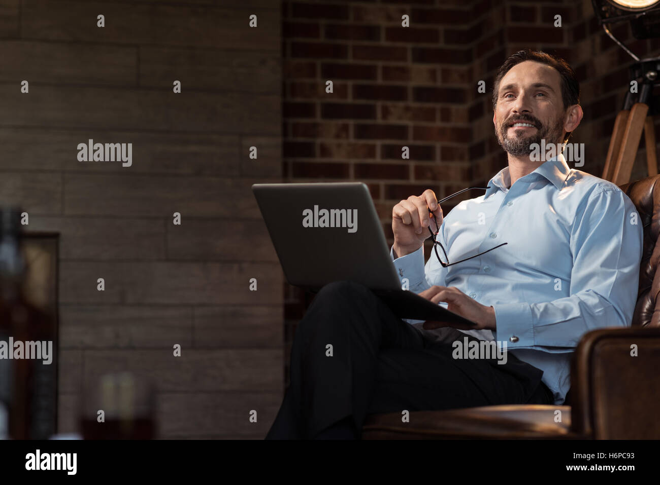 Cheerful self employed man holding his glasses Stock Photo - Alamy