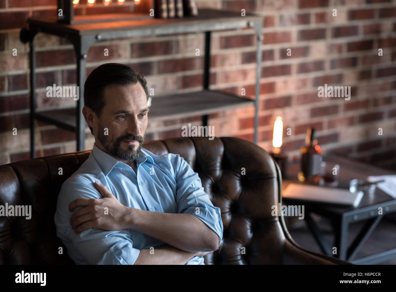 Nice good looking man wrapping his arms around him Stock Photo - Alamy
