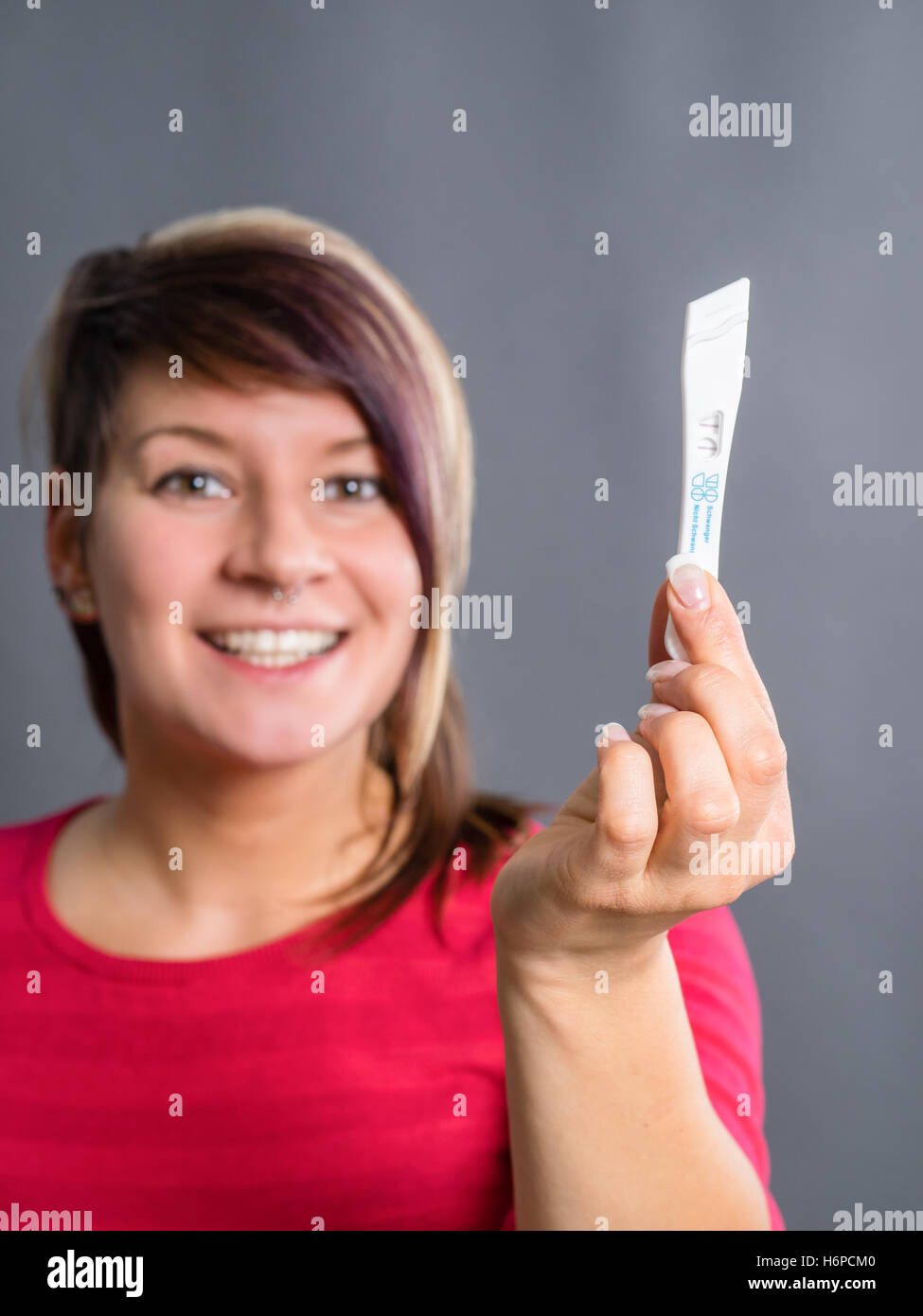 Joyful and surprised woman showing positive pregnancy test Stock Photo ... Joyful and surprised woman showing positive pregnancy test Stock Photo ...