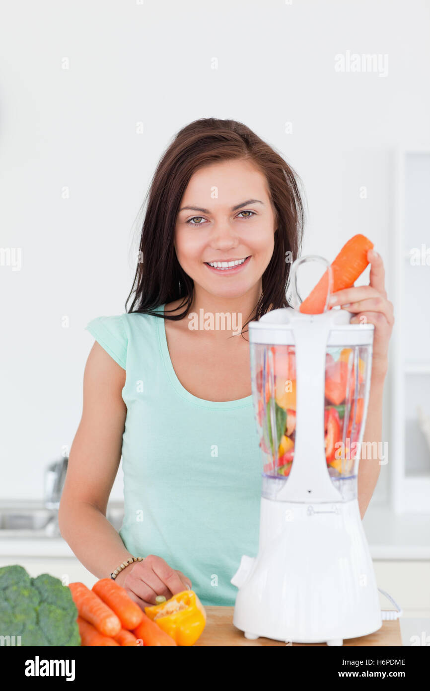 Young woman using a blender in her kitchen Stock Photo - Alamy