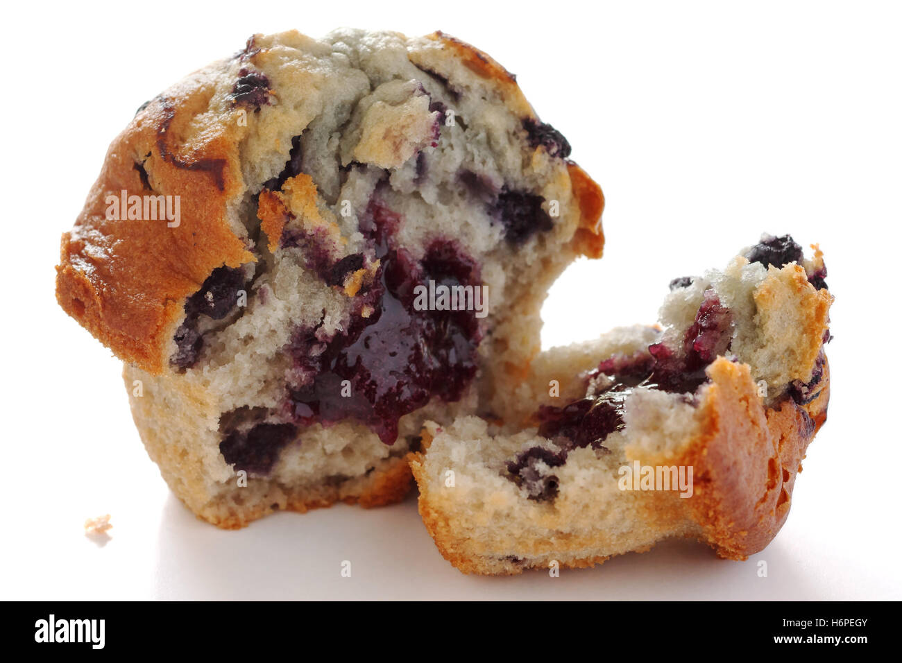 Broken blueberry muffin on white surface Stock Photo - Alamy