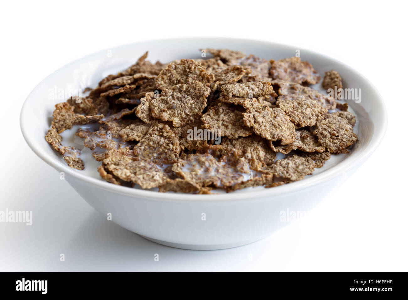 Wheat bran breakfast cereal with milk in a bowl isolated on white ...