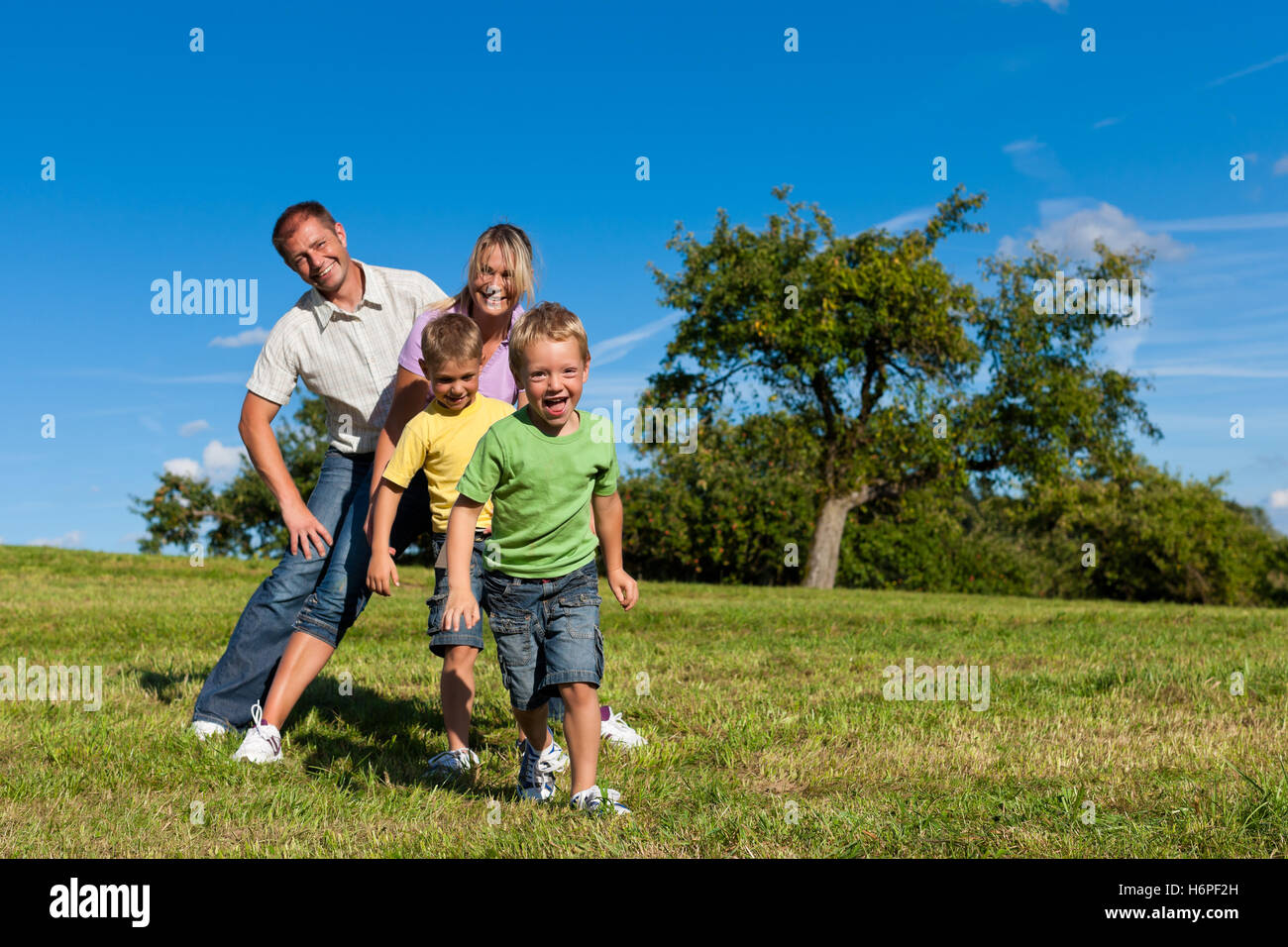 family with children playing on a meadow Stock Photo - Alamy