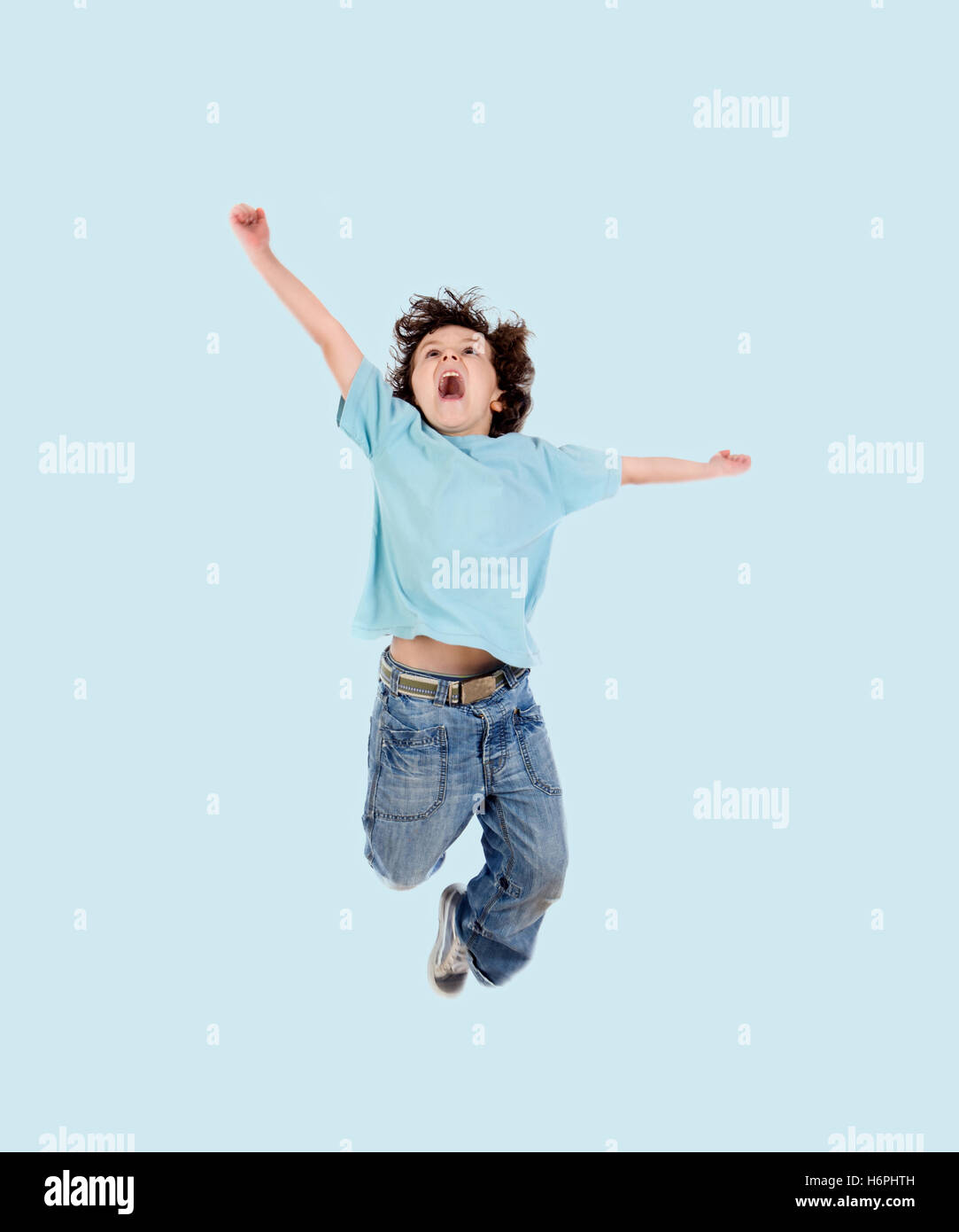 Adorable child jumping on a blue background Stock Photo - Alamy