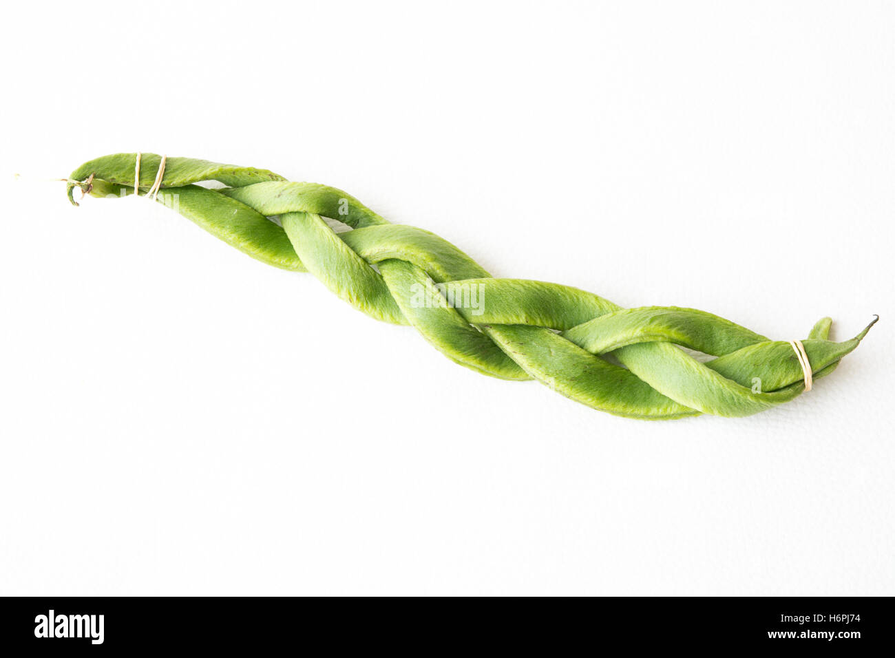 Runner beans plaited on a white background Stock Photo - Alamy