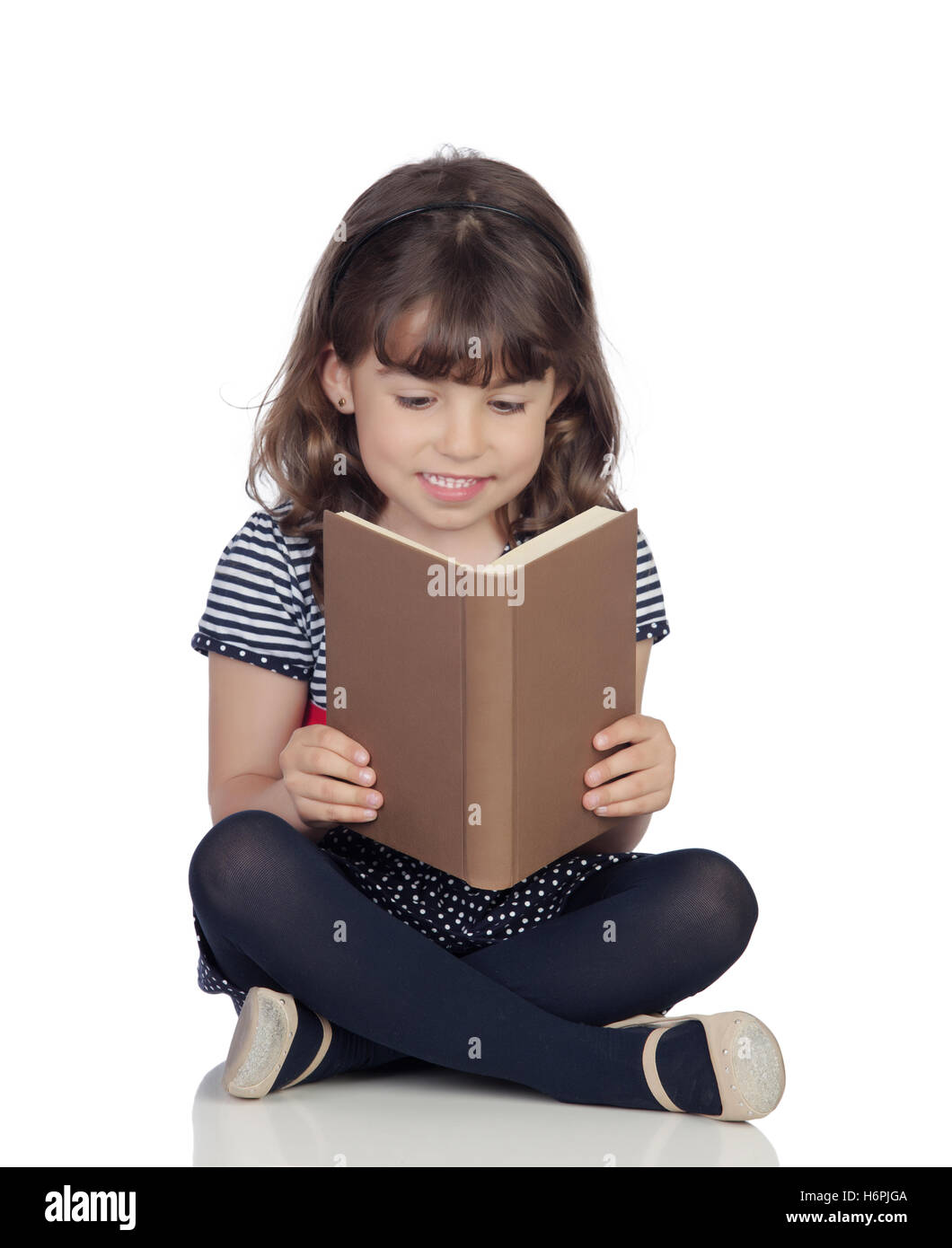 Adorable little girl with a book reading isolated on white background ...