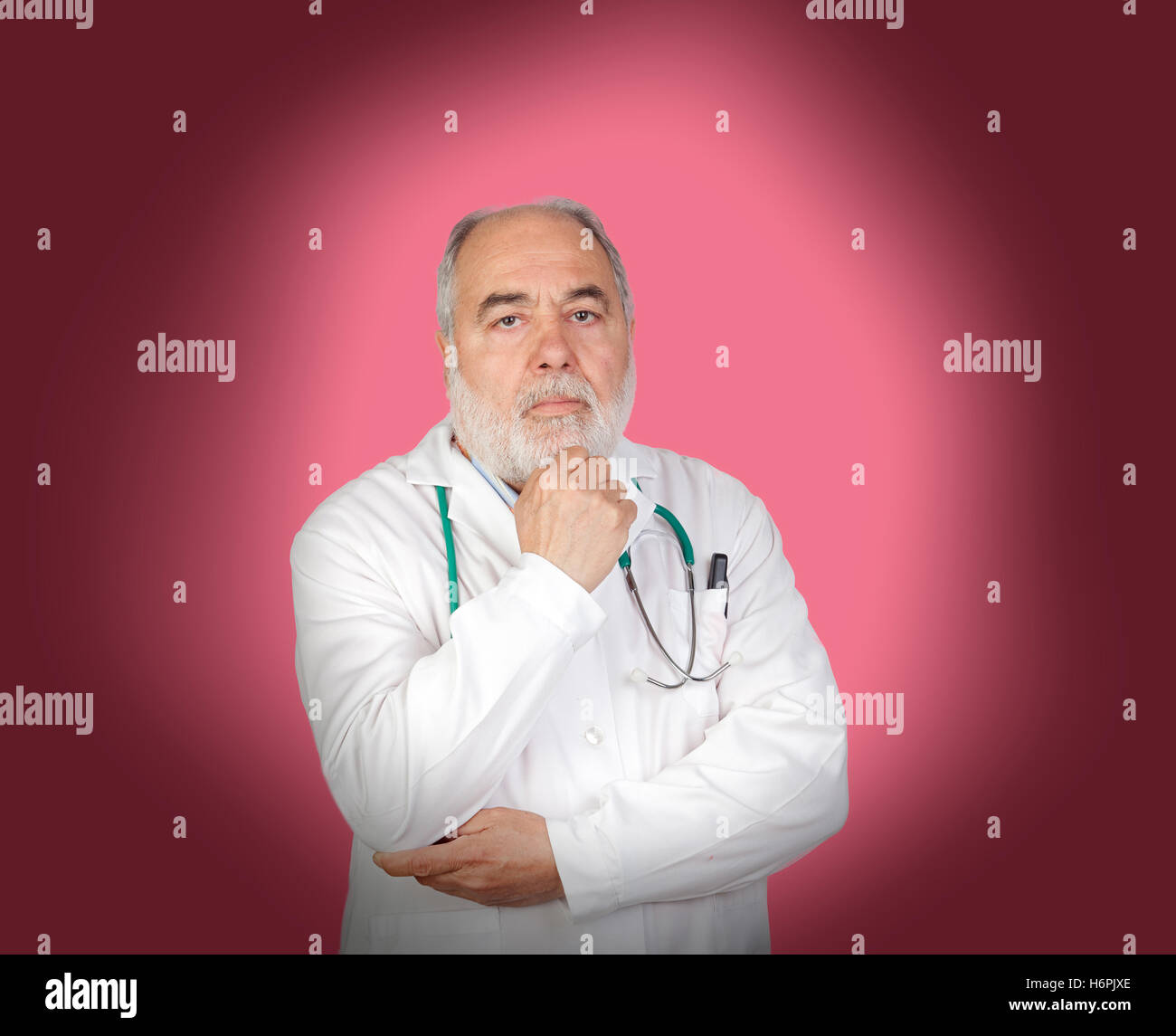 Thoughtful old doctor on a over pink background Stock Photo - Alamy
