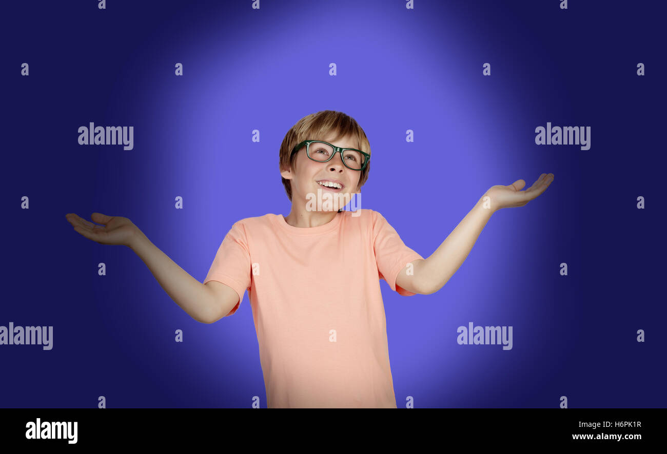 Smiling boy with a doubtful expression on a over blue background Stock ...