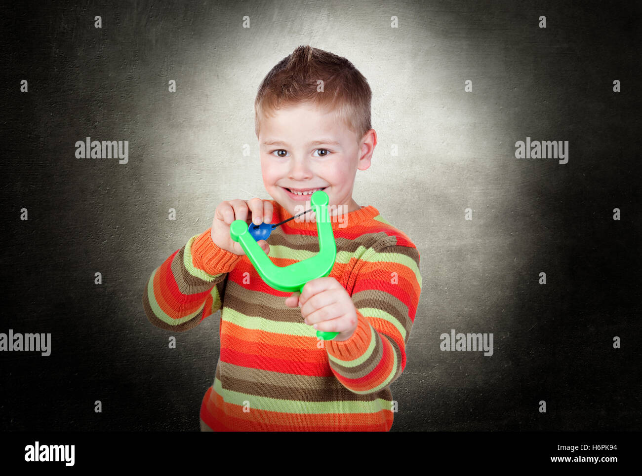 Portrait Of A Happy Boy Playing With Slingshot indoor Stock Photo - Alamy