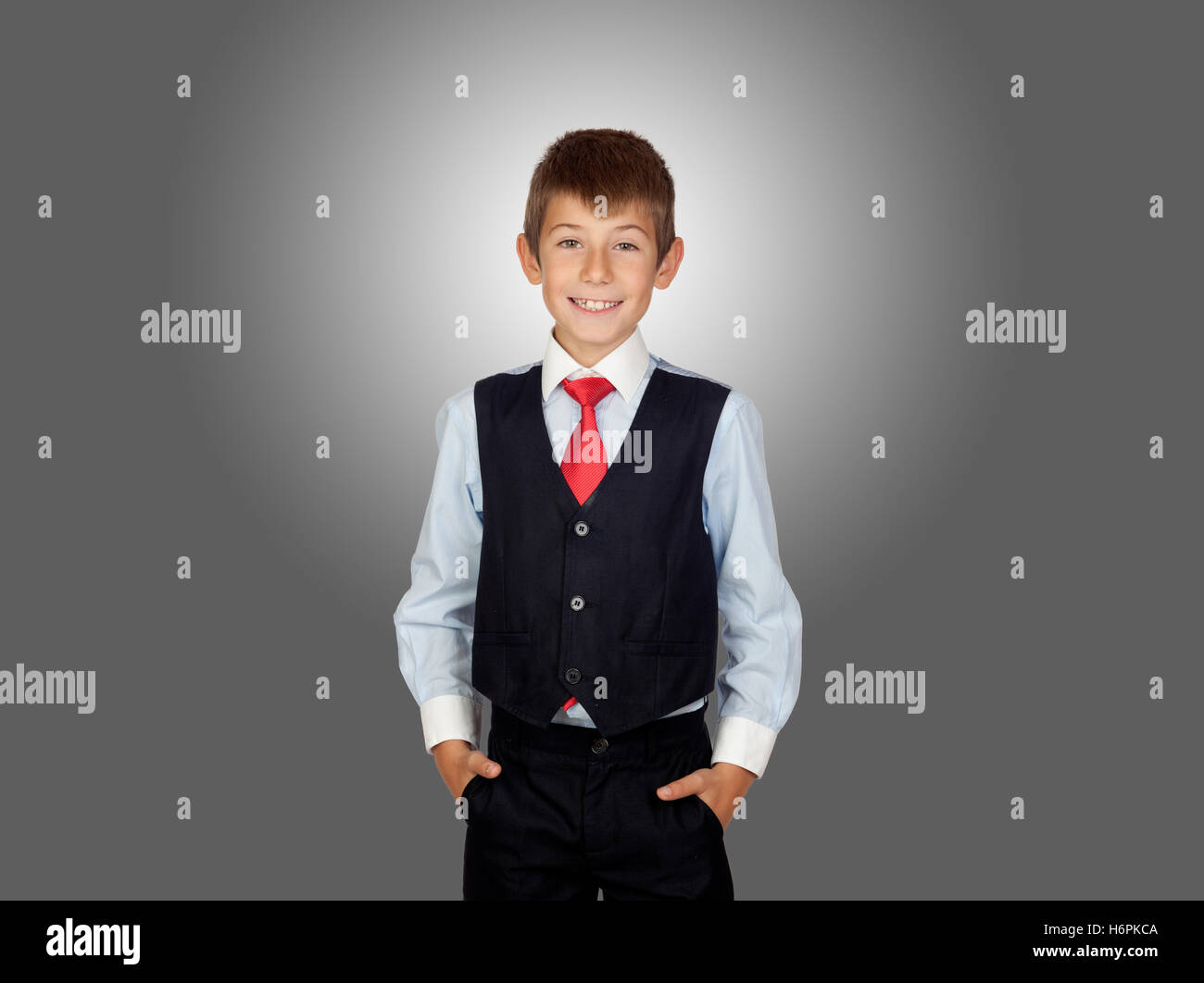 Smiling little businessman on a over gray background Stock Photo - Alamy